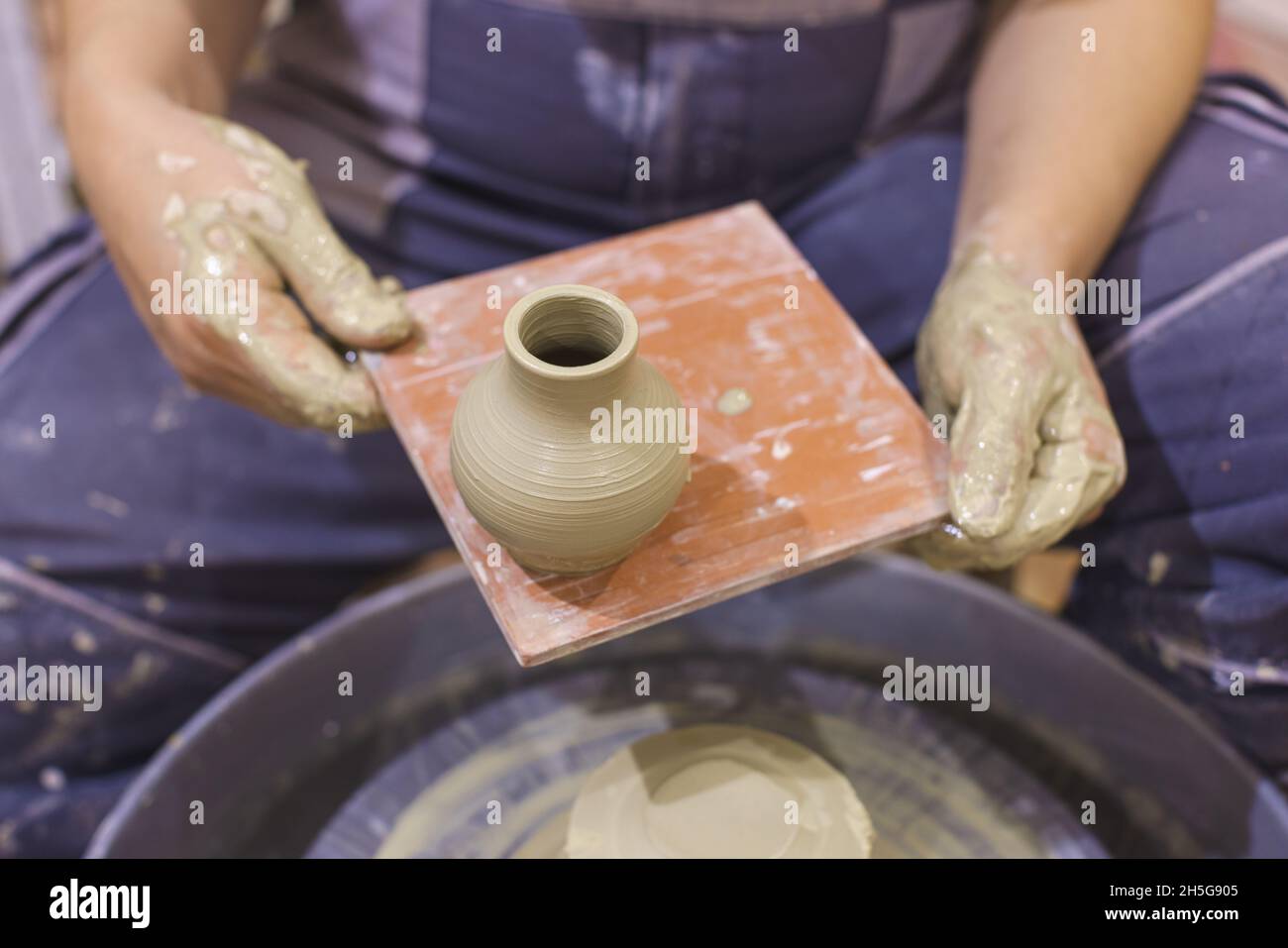 Pottery artist showing clay vase in ceramic studio. Creative handmade ...