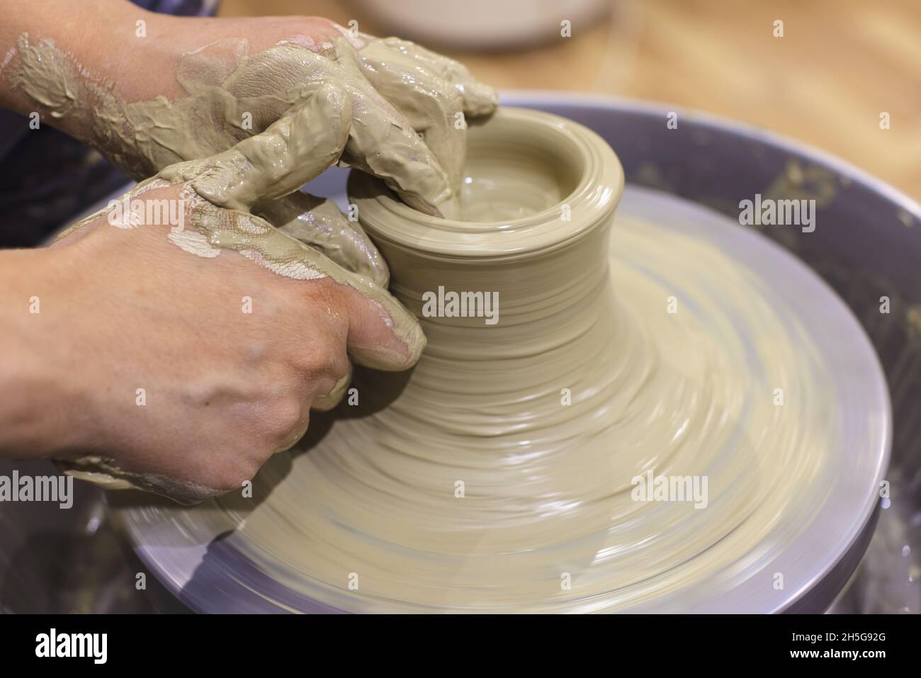 Female pottery artist shapes the clay on pottery wheel. Creative ...