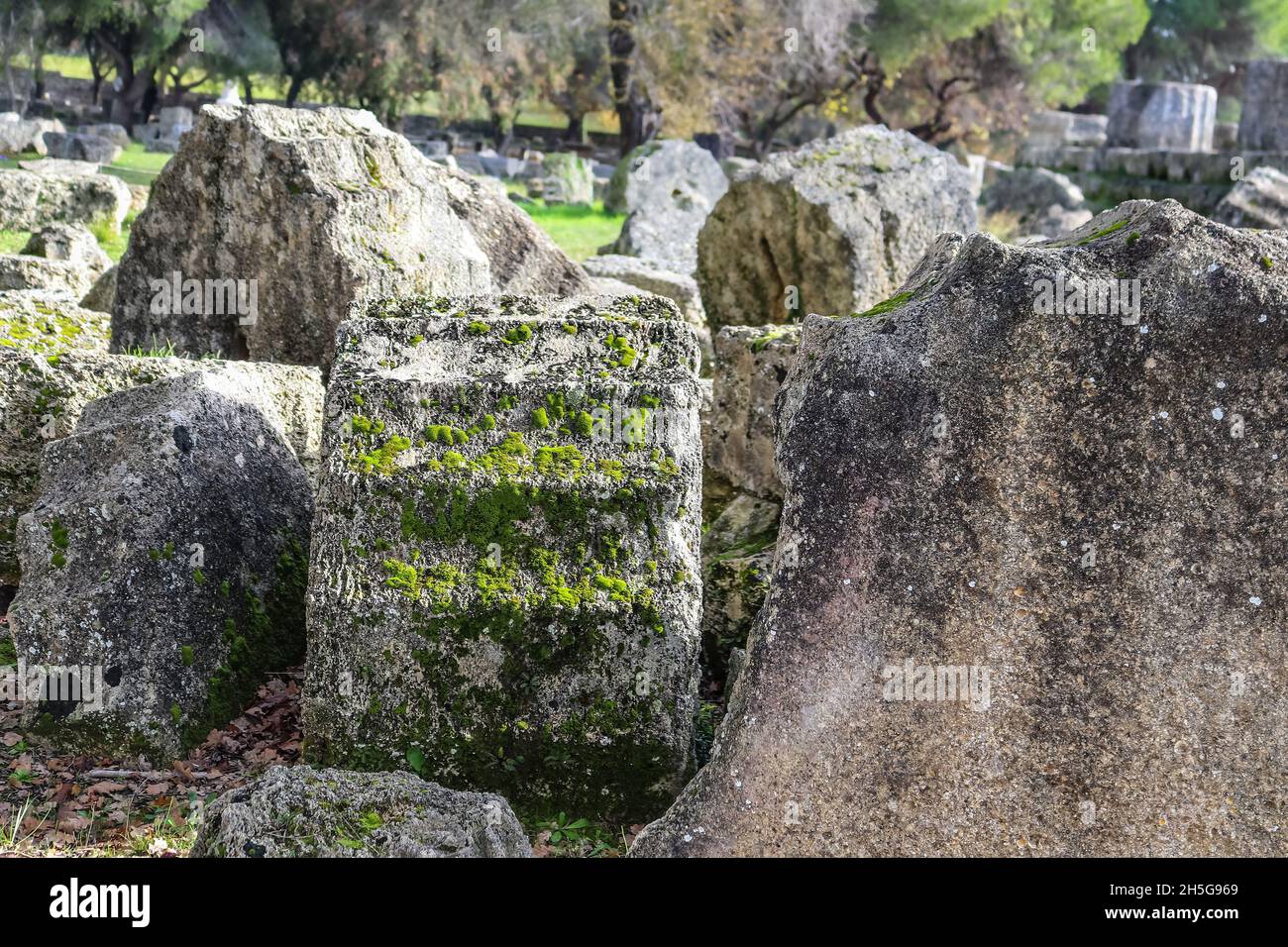 Fallen pieces of classical pillars pitted with age and growing moss at ...