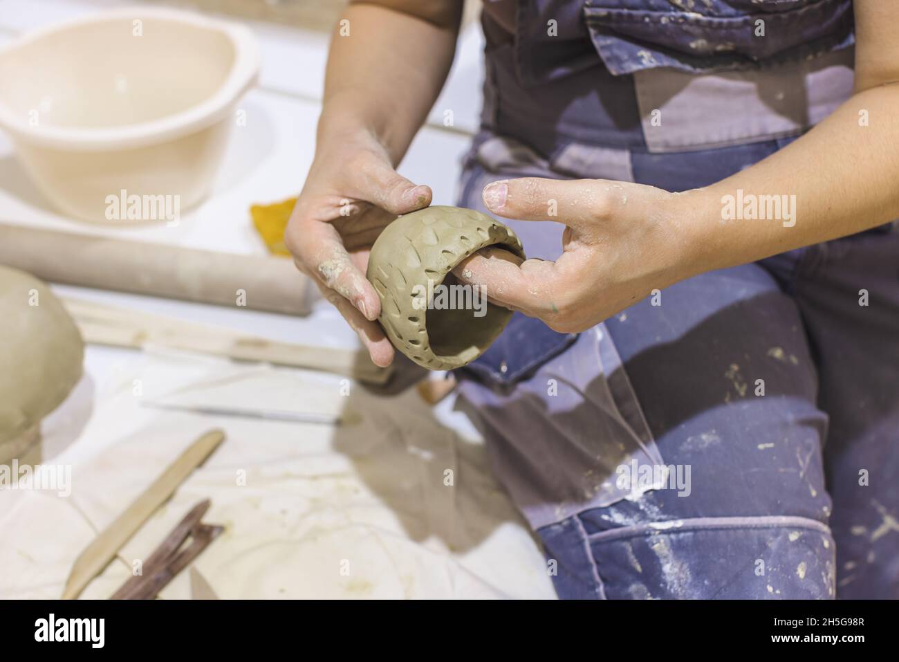 Female pottery artist working on clay bowl. Creative handmade craft ...