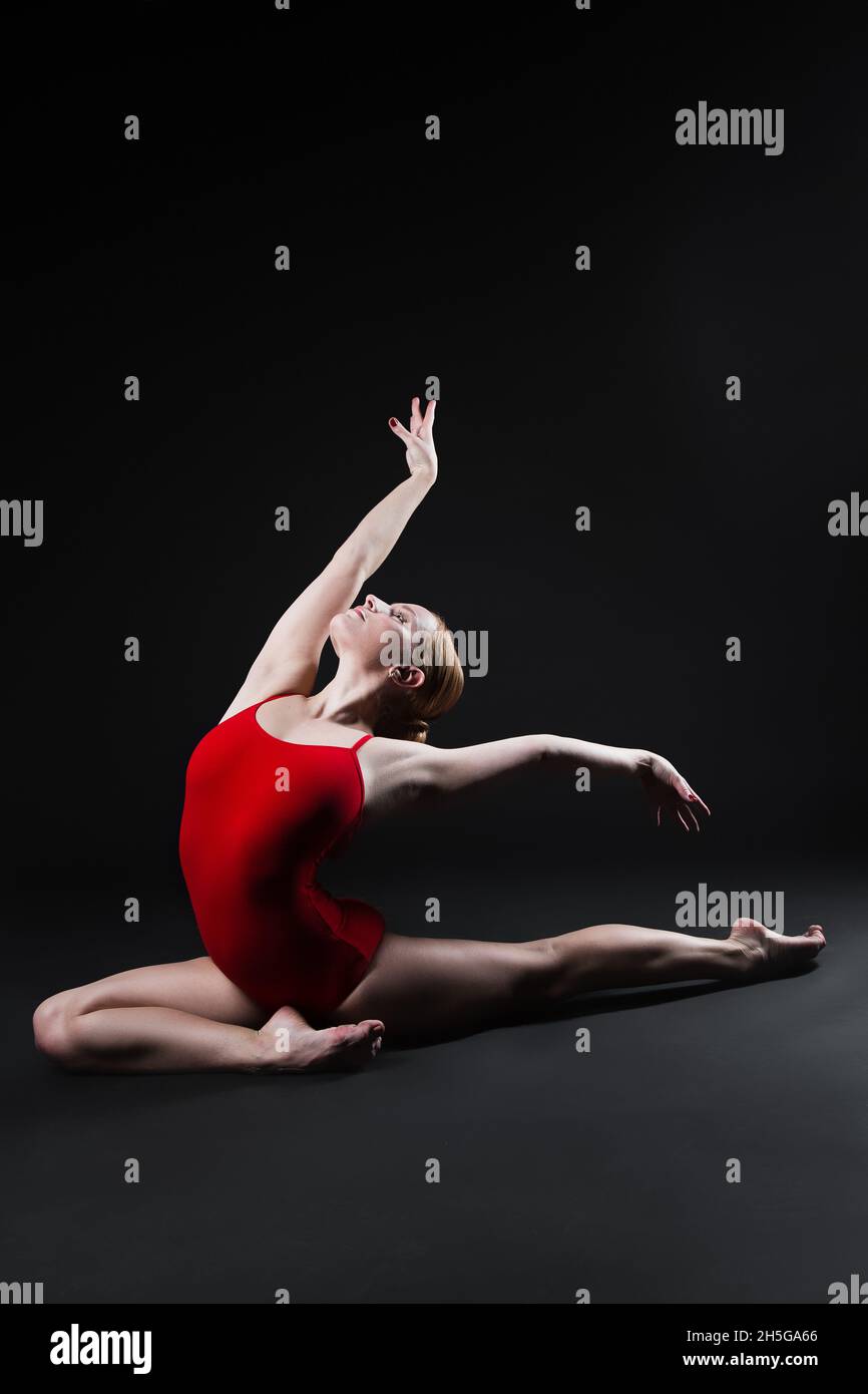 beautiful adult girl gymnast shows muscle strength and body beauty ...