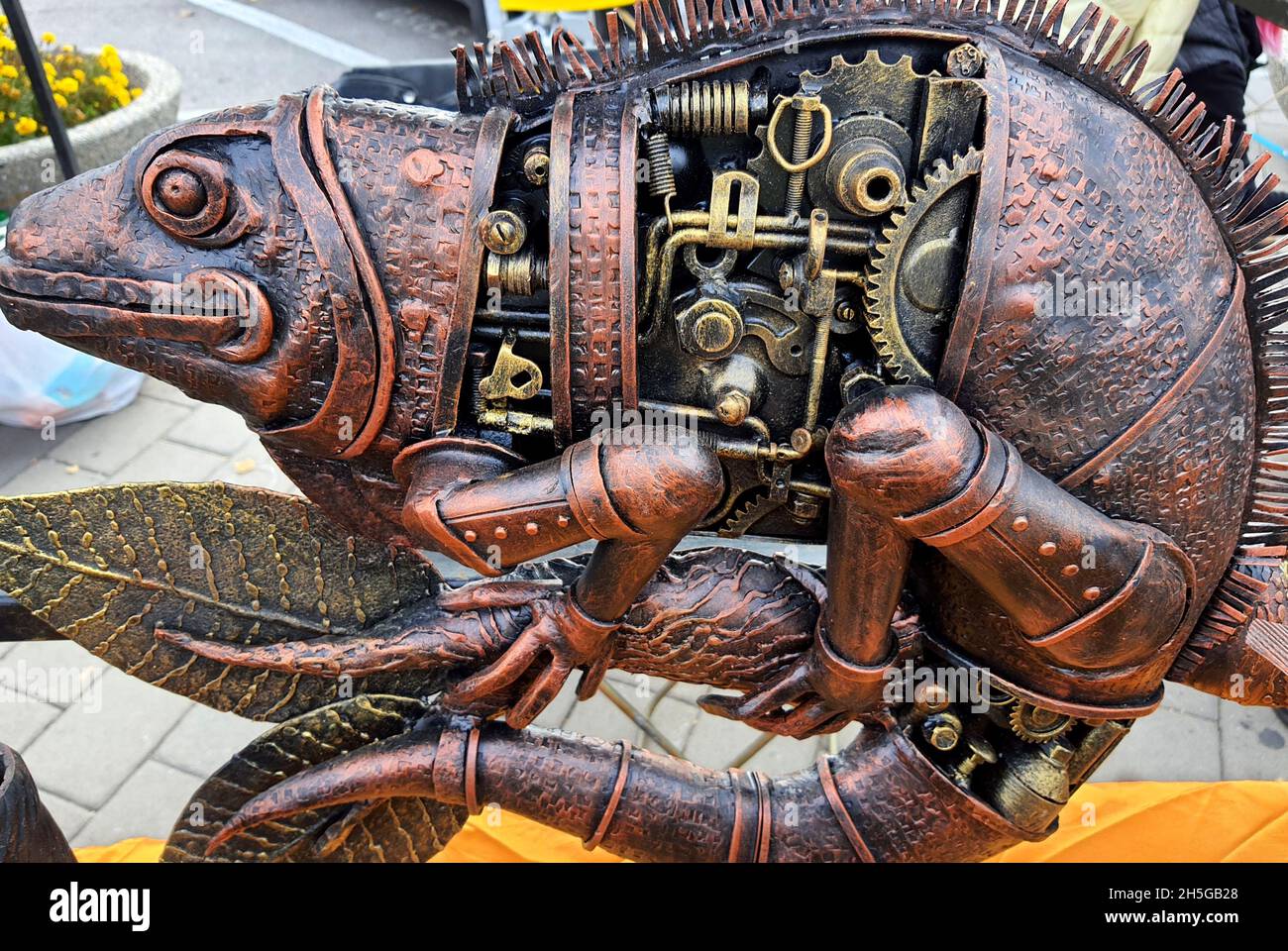 A forged metal figurine, funny unusual iron iguana are presented at ...