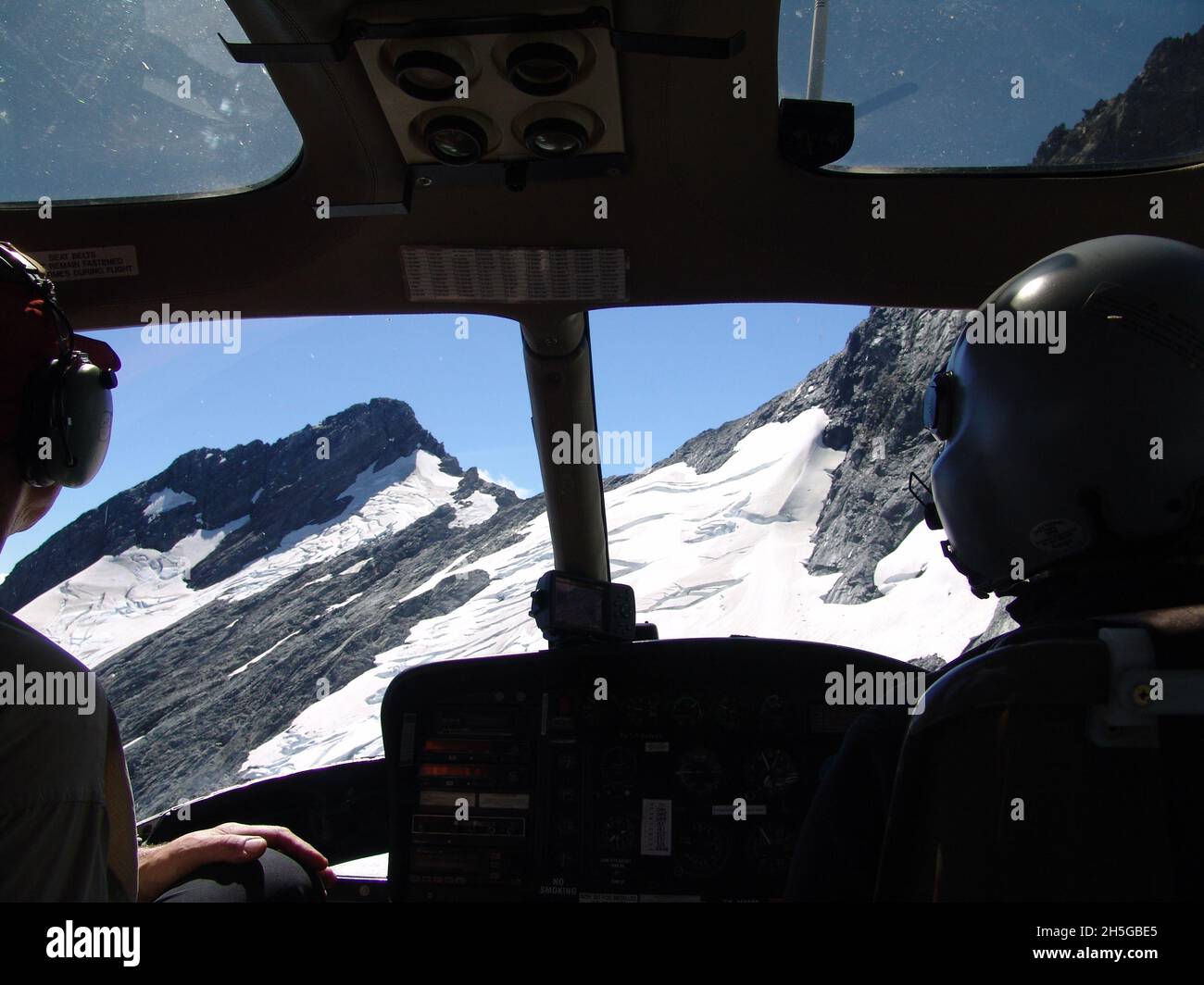 Pilots' view during the flight over mountains from the helicopter cabin ...