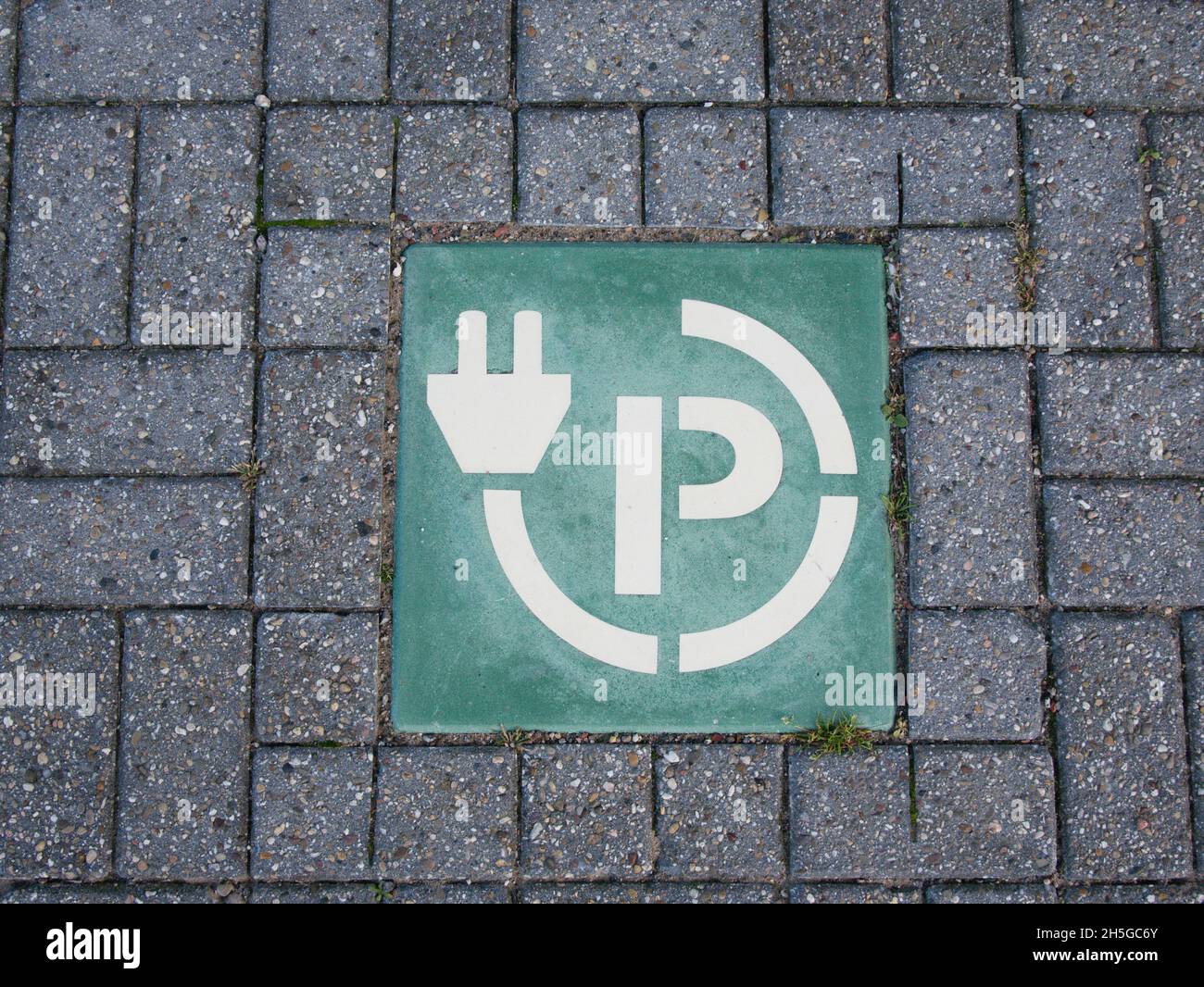A sign on the ground showing parking with charge points for electric ...