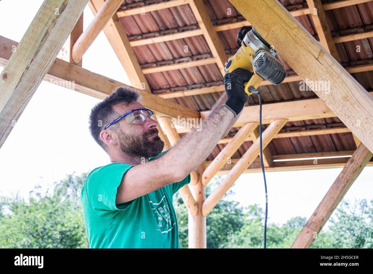 Worker grinds the wood of angular grinding machine at his workstation ...