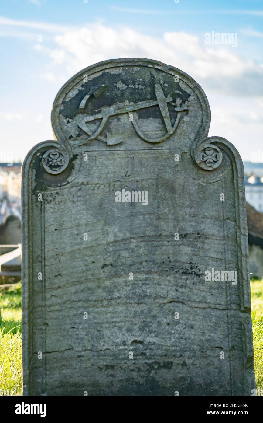 Old headstone or gravestone with an ornate carving believed to be the ...