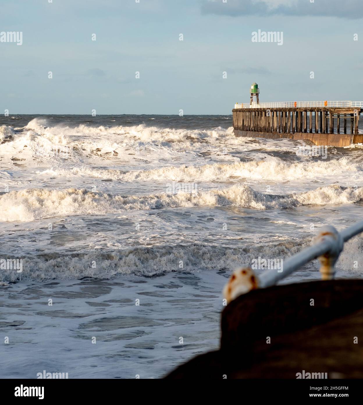 White water, waves and surf rolling in and crashing against the harbour ...