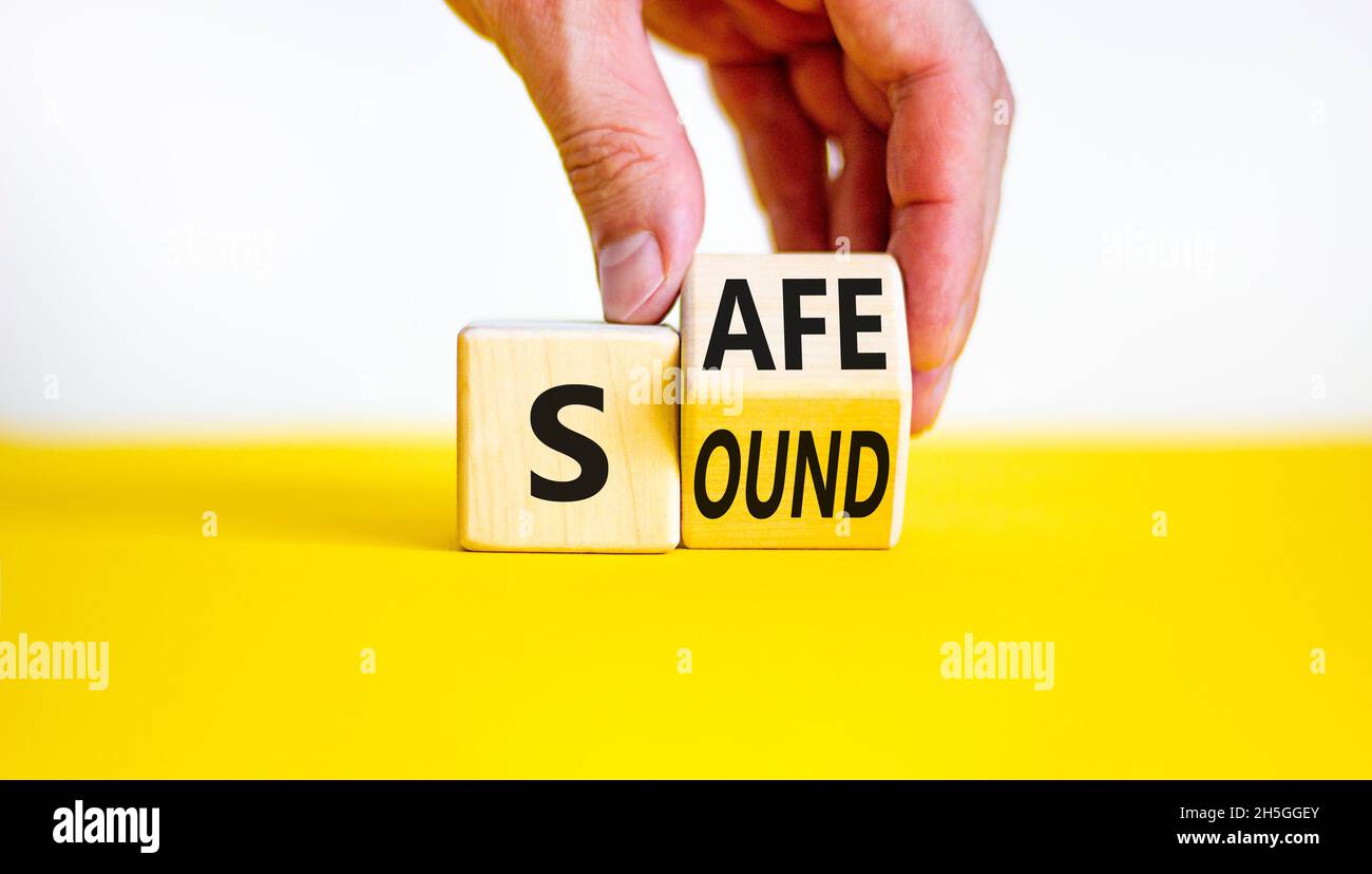 Safe and sound symbol. Businessman turns a wooden cube and changes the ...