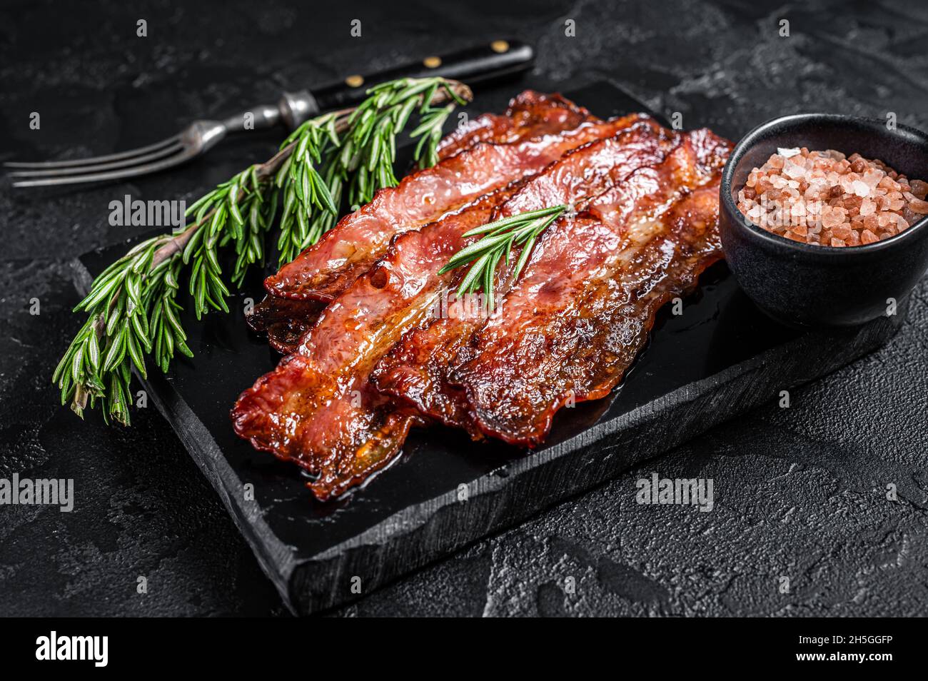 Fried crunchy Streaky Bacon stripes. Black background. Top view Stock ...