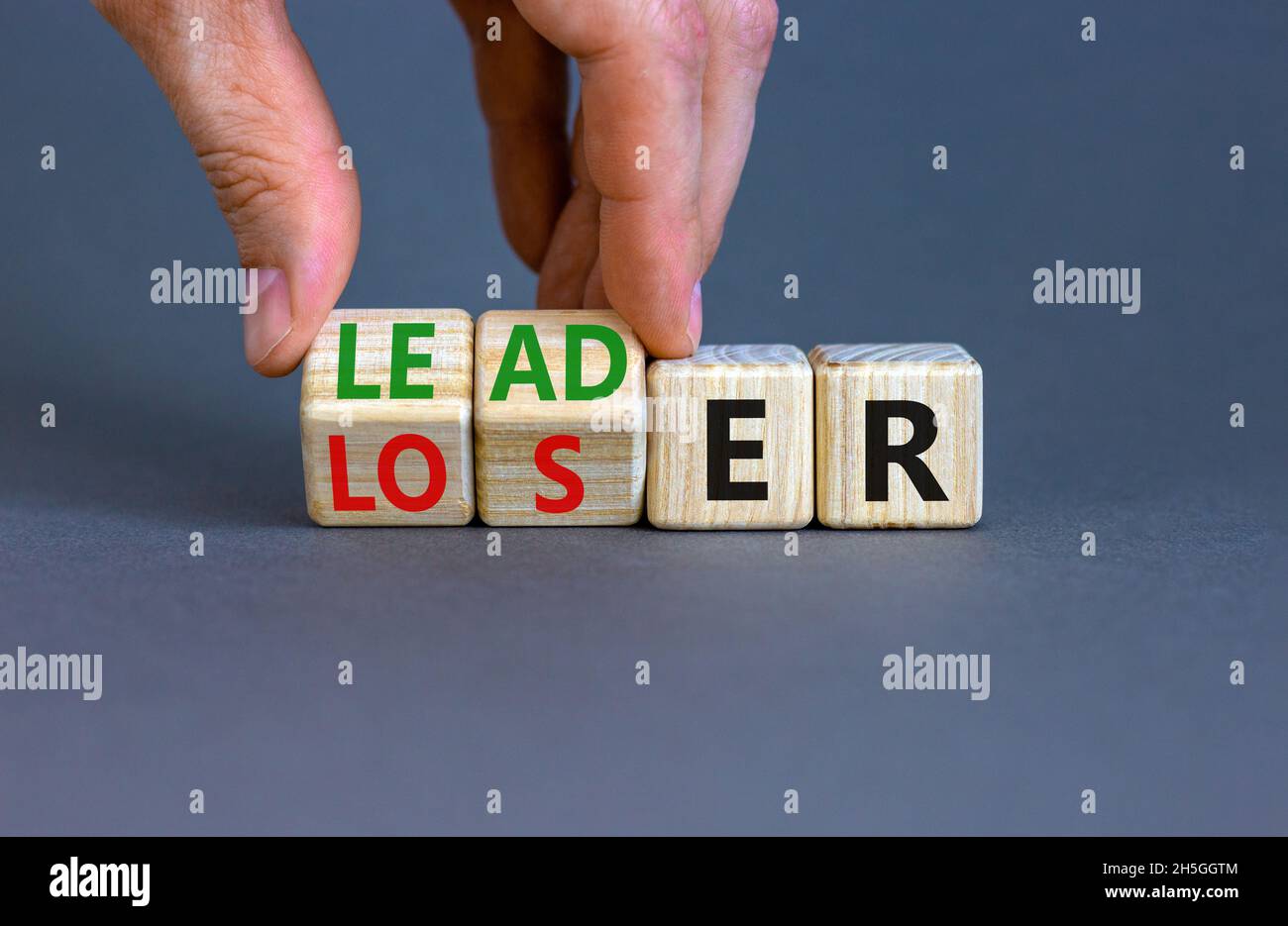 Loser or leader symbol. Businessman turns cubes and changes the word ...