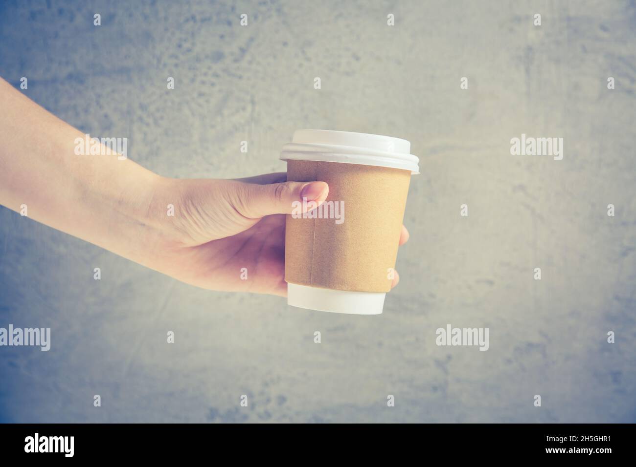 Hand holding disposable coffee cup Stock Photo - Alamy