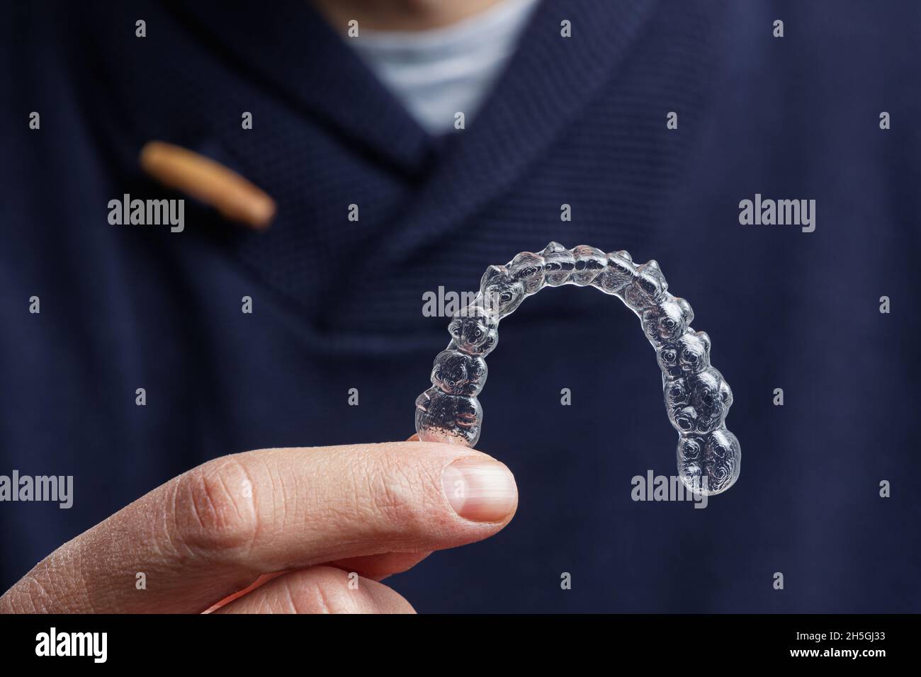 Man holding one transparent aligner. Invisalign orthodontics concept ...