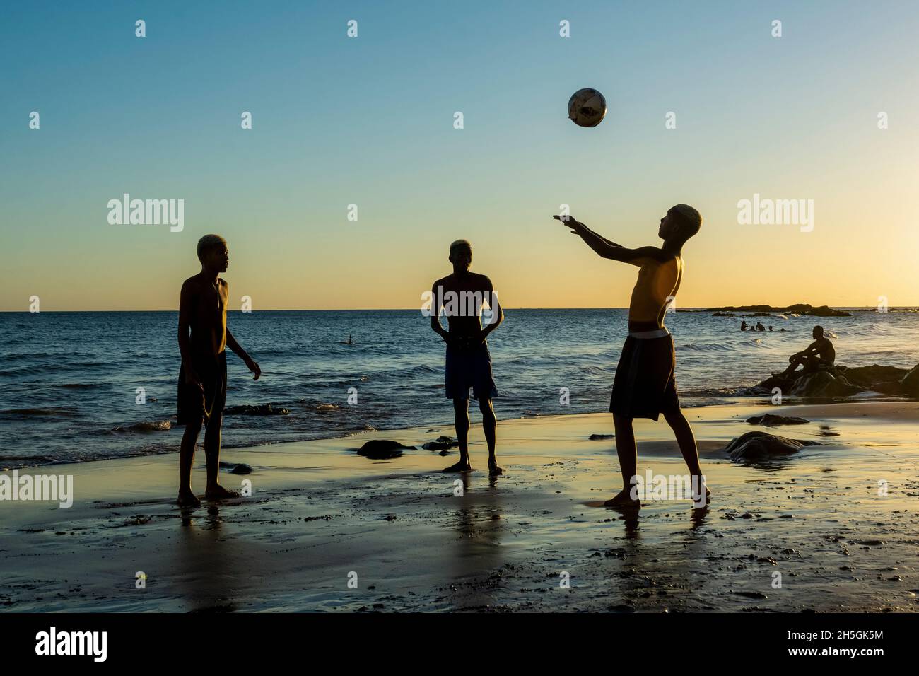 Young people playing sand football at sunset on Ondina beach in ...
