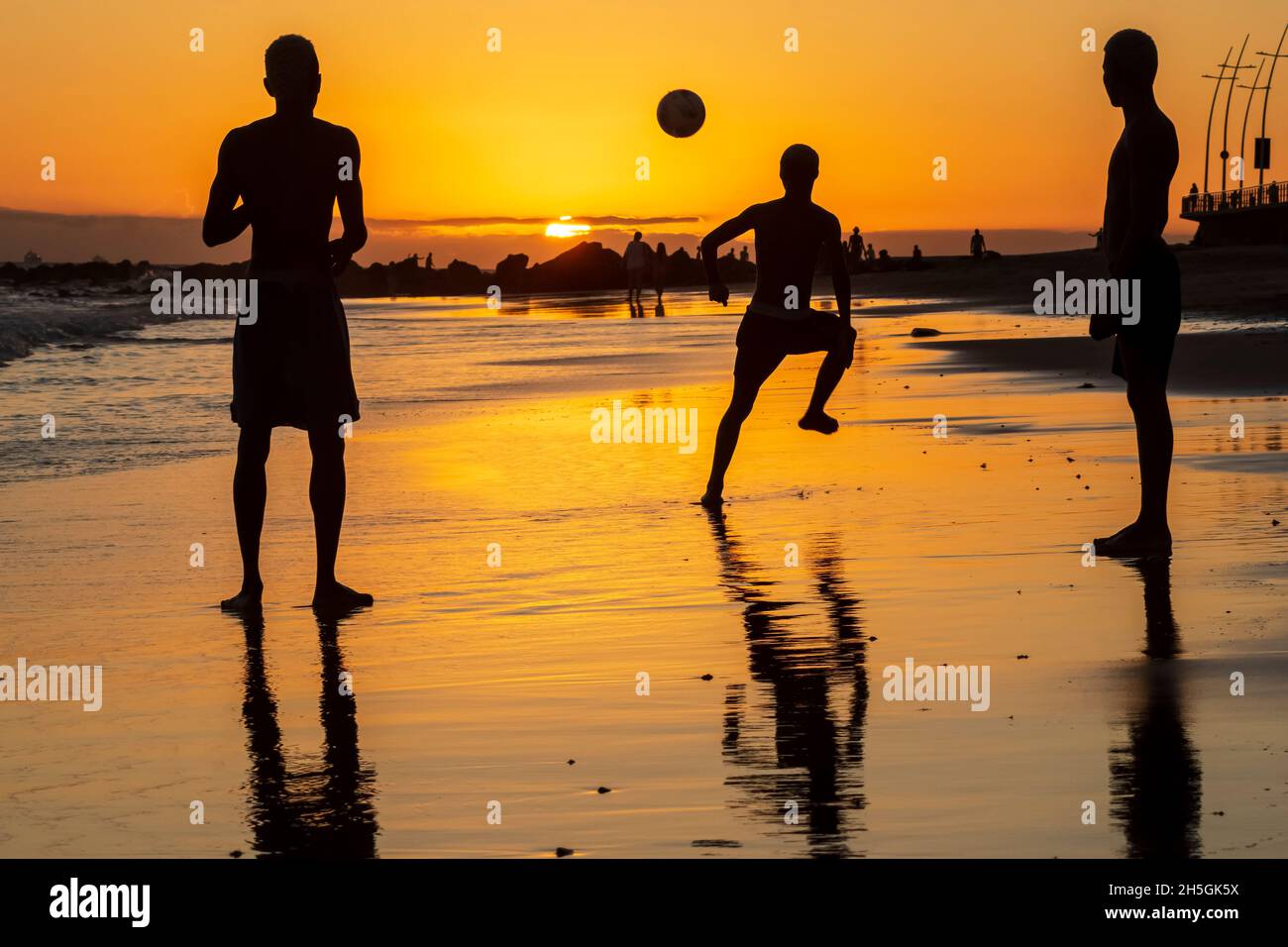 Young people playing sand football at sunset on Ondina beach in ...