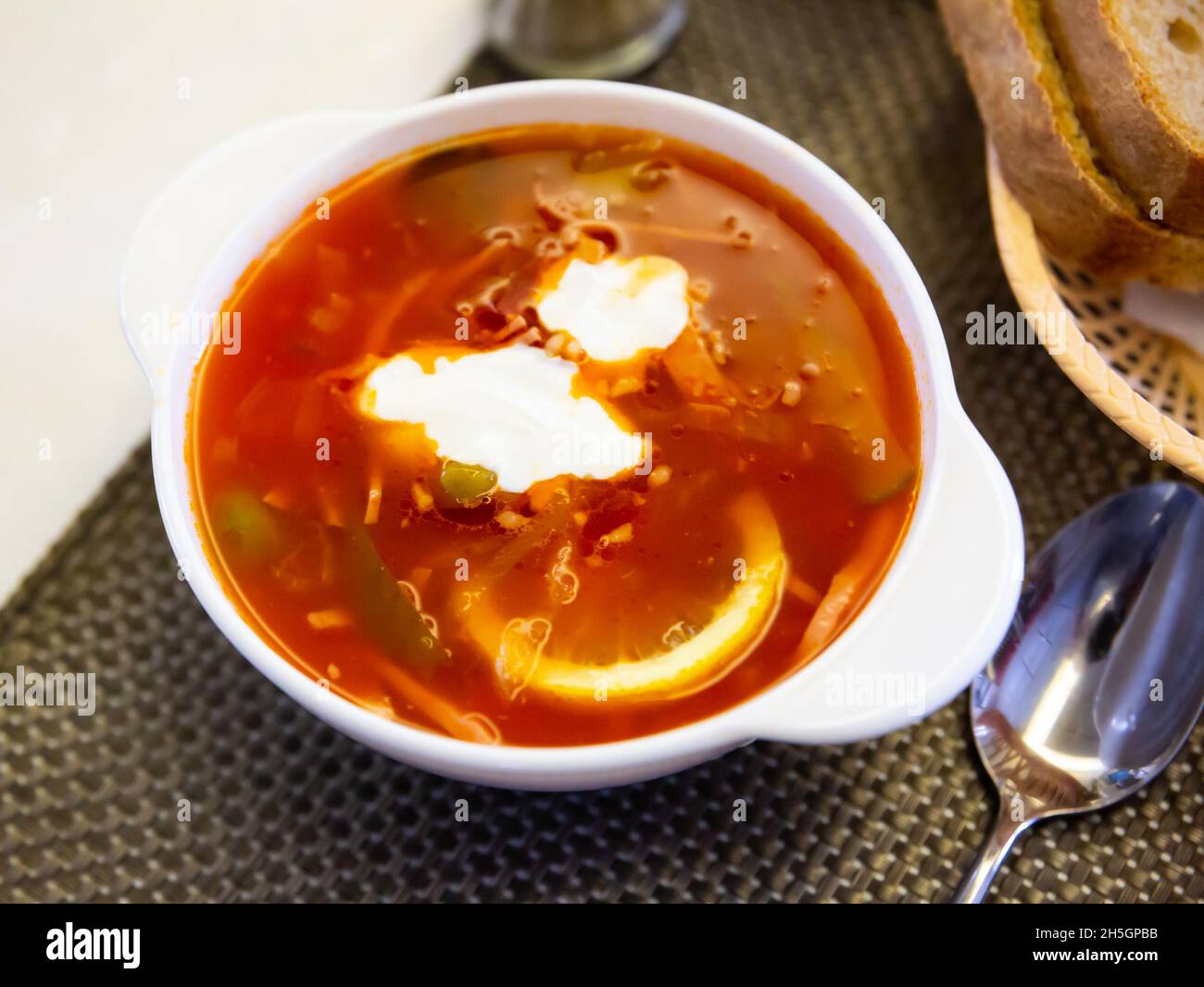Traditional Russian meat soup Solyanka with sour cream and lemon Stock ...