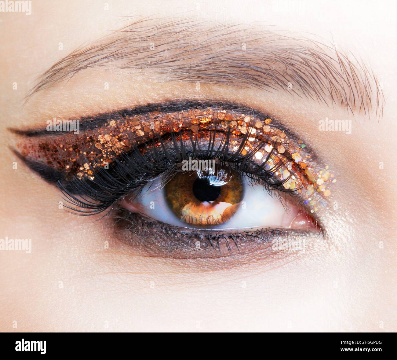Close-up shot of female face with vogue golden shining eyes makeup ...