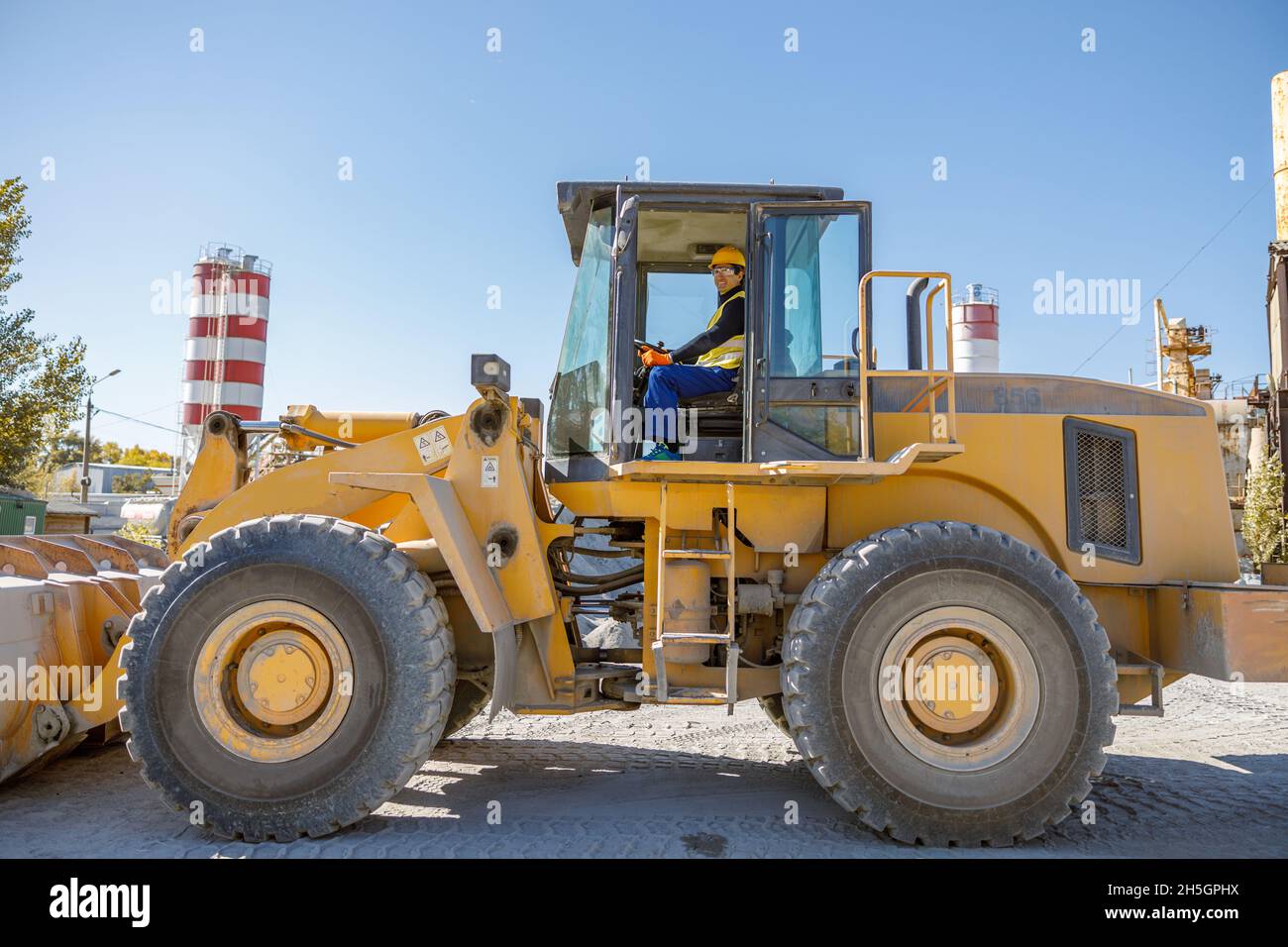 Cheerful man driving industrial truck at factory Stock Photo - Alamy