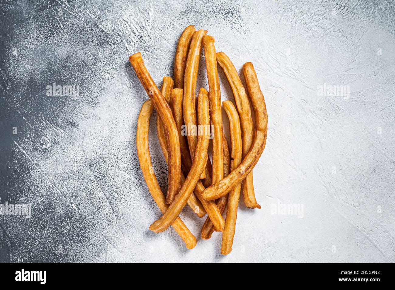 Churros fried sticks on kitchen table. White background. Top view Stock ...