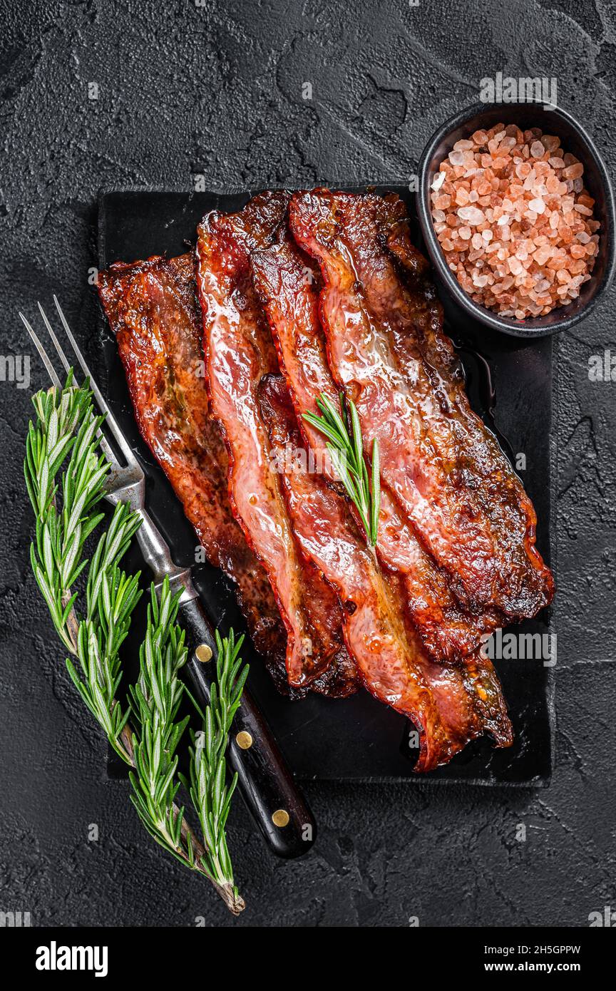 Fried crunchy Streaky Bacon stripes. Black background. Top view Stock ...