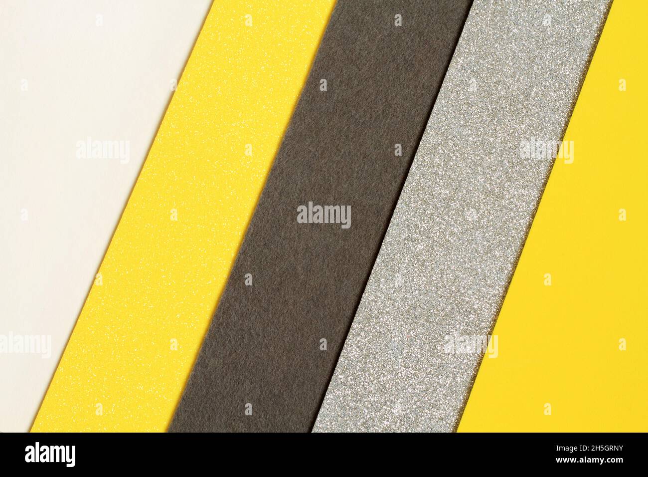 Gray, siver and yellow foamiran sheets folded on a white sheet of ...