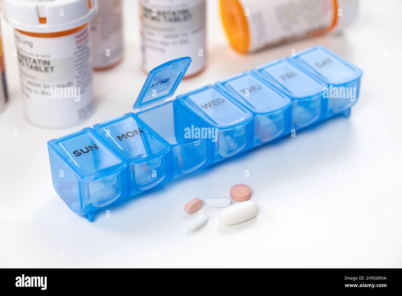 Blue color medicine organizer with prescription bottles isolated on ...
