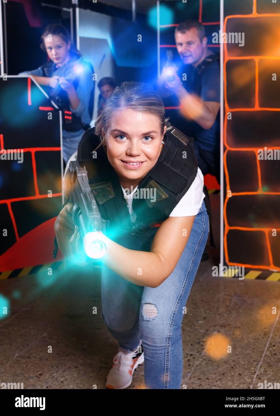joyous girl with laser pistol playing laser tag with friends Stock ...