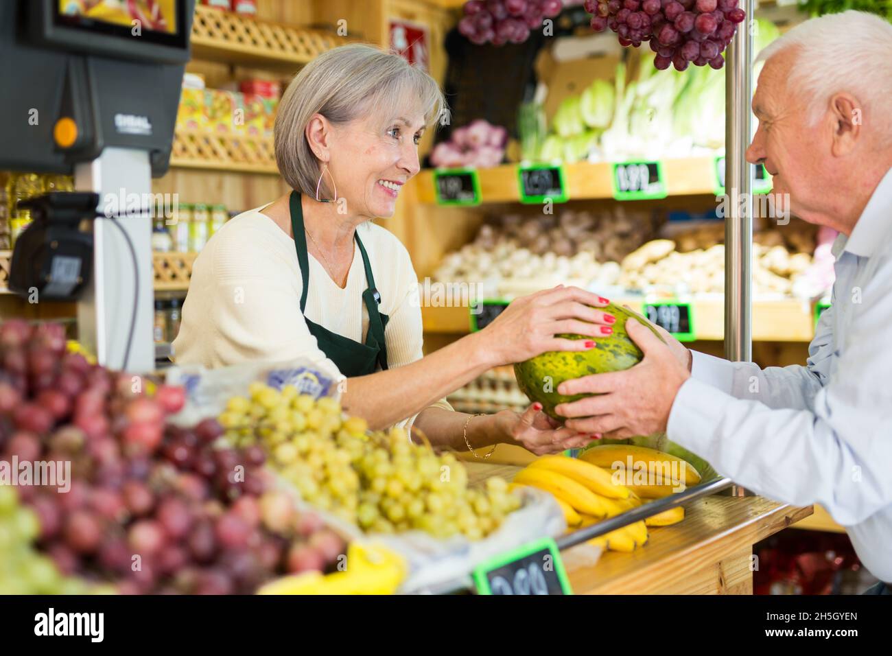 Senior cashier woman serving customer in greengrocer Stock Photo - Alamy