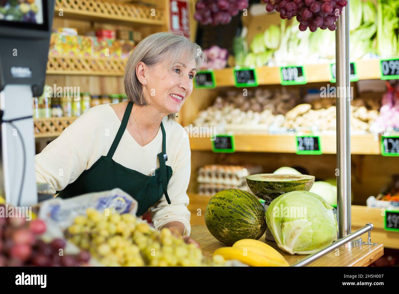 Saleswoman standing at counter in greengrocer Stock Photo - Alamy