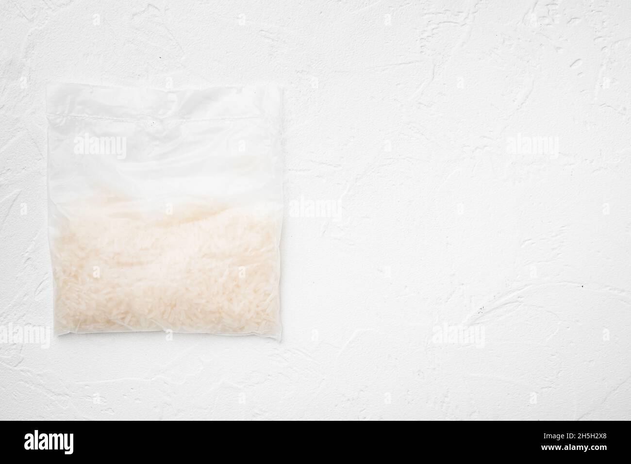 Rice in portion bags set, on white stone table background, top view ...