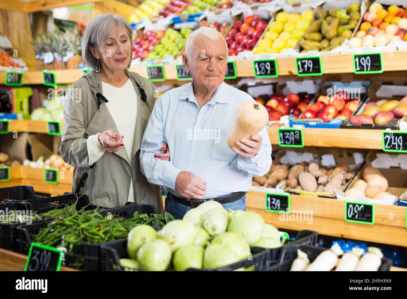 Mature couple choosing vegetables in greengrocer Stock Photo - Alamy