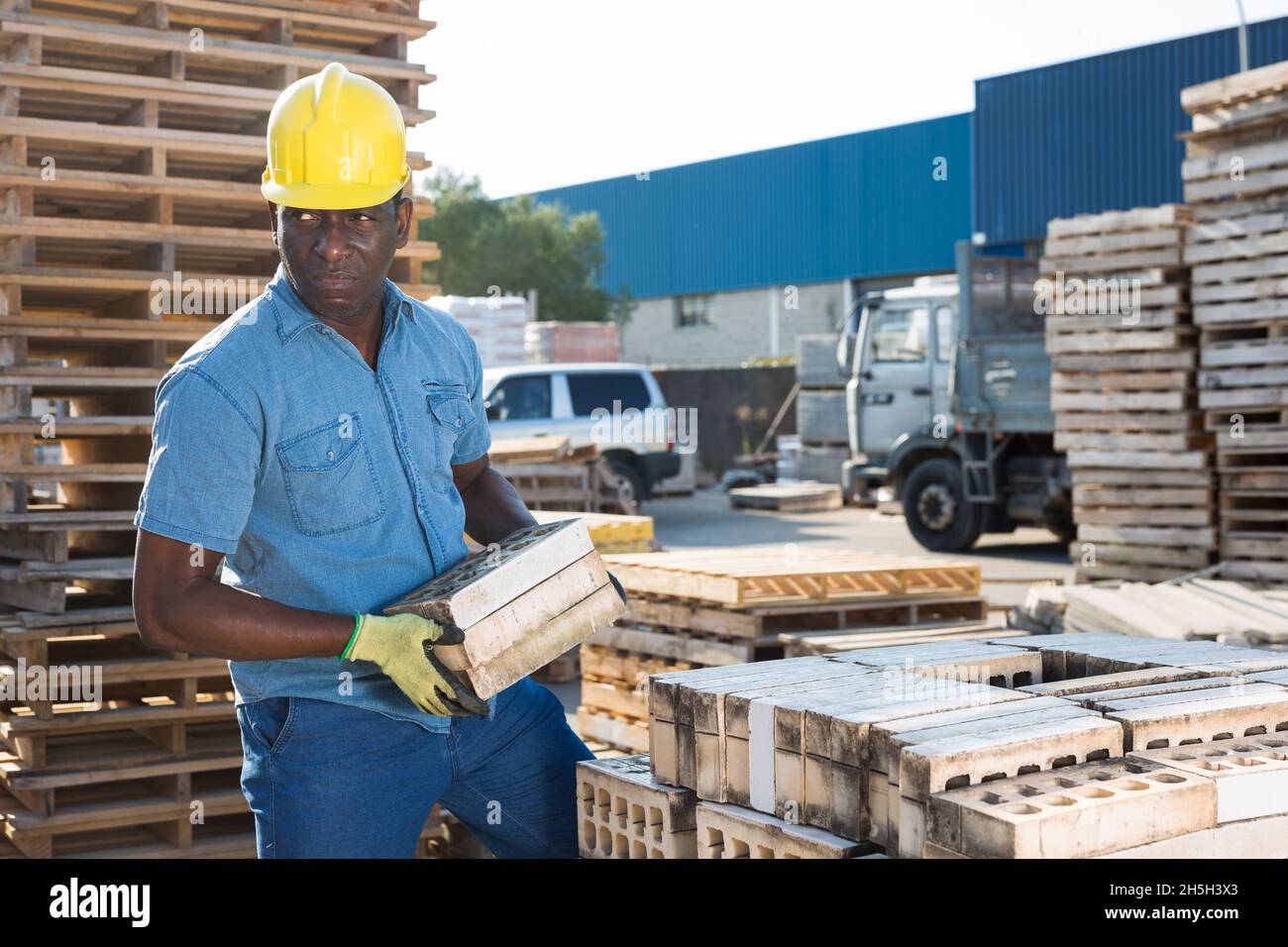 Man carrying hollow concrete blocks outdoors Stock Photo - Alamy