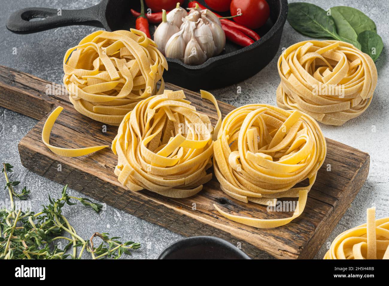 Raw tagliatelle nests Traditional Italian pasta set, on gray stone ...