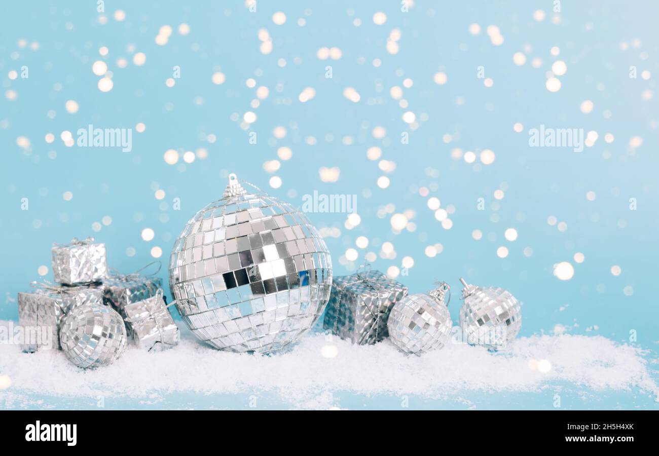 Christmas toy disco ball slugs on pastel blue background, snow sparkles ...
