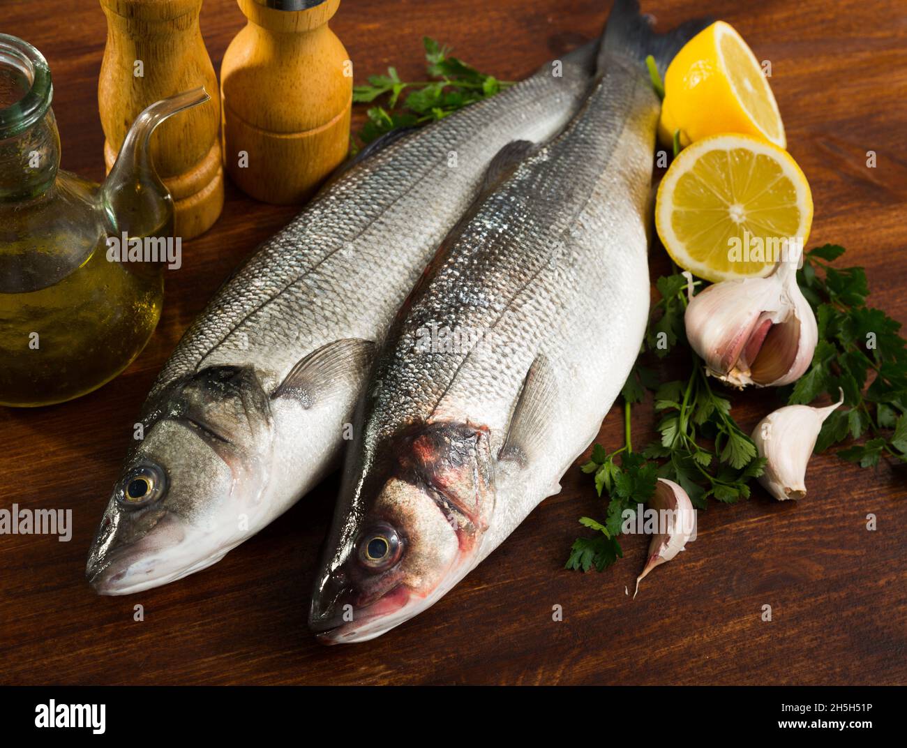 Two raw sea bass fish Stock Photo - Alamy