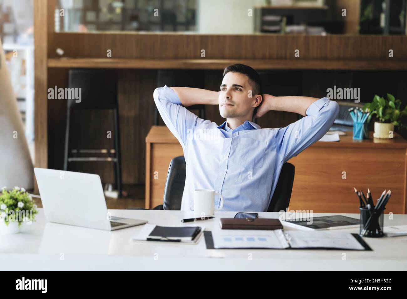 Male marketing manager resting and smiling while working to reduce ...