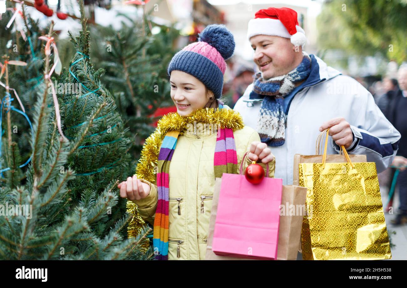 Girl with father choosing Xmas tree Stock Photo - Alamy