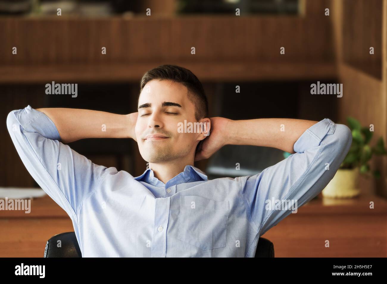 Male marketing manager resting and smiling while working to reduce ...