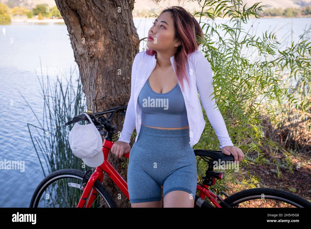 Young Woman Leaning on Bicycle Lakeside Stock Photo - Alamy