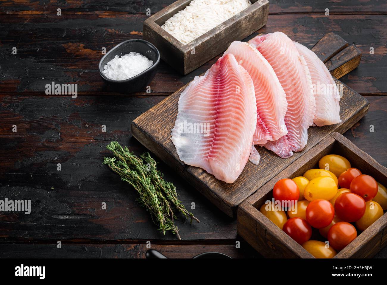 Raw white fish tilapia, with basmati rice and cherry tomatoes ...