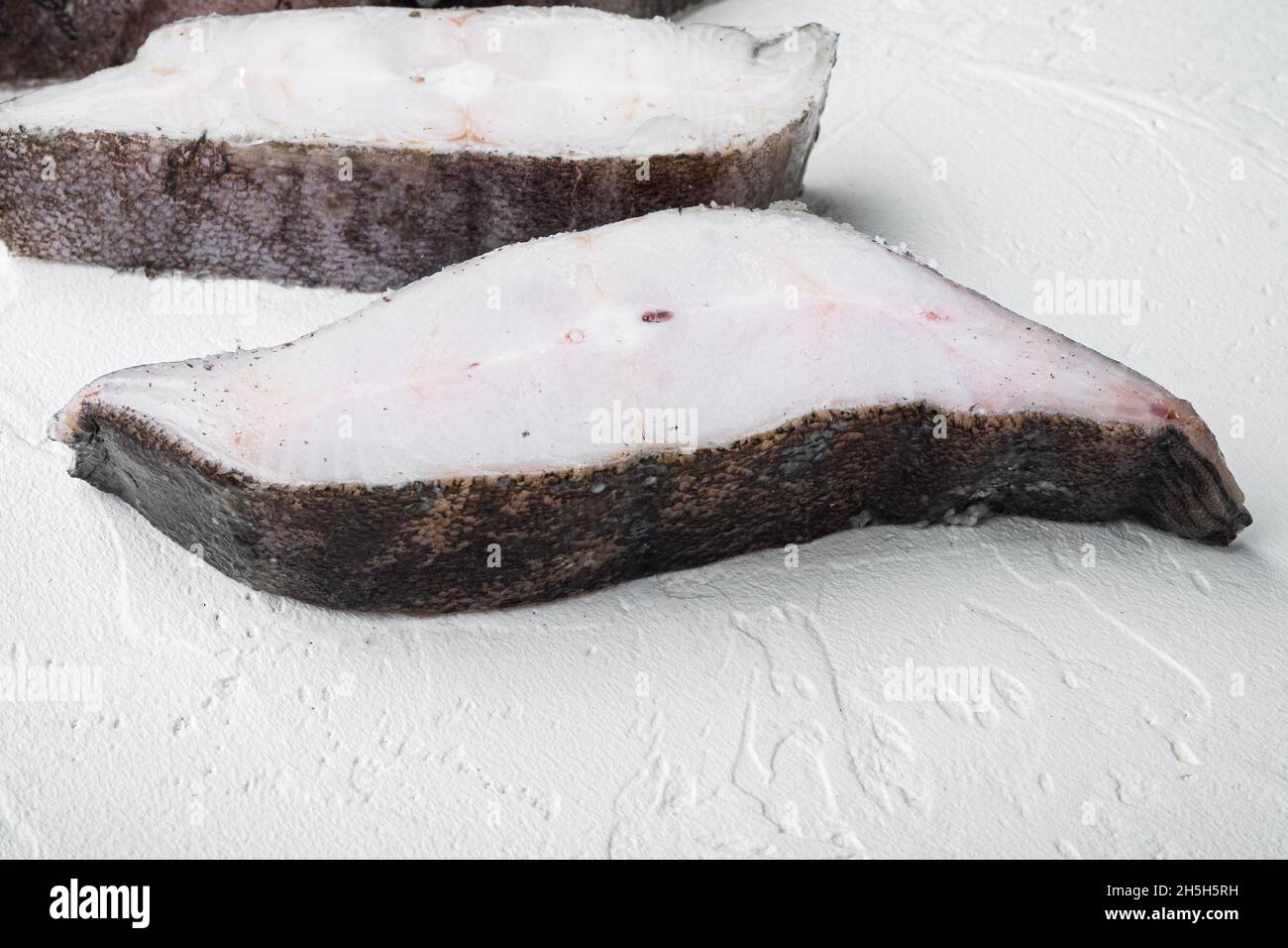 Halibut fish frozen steak set, on white stone table background, with ...