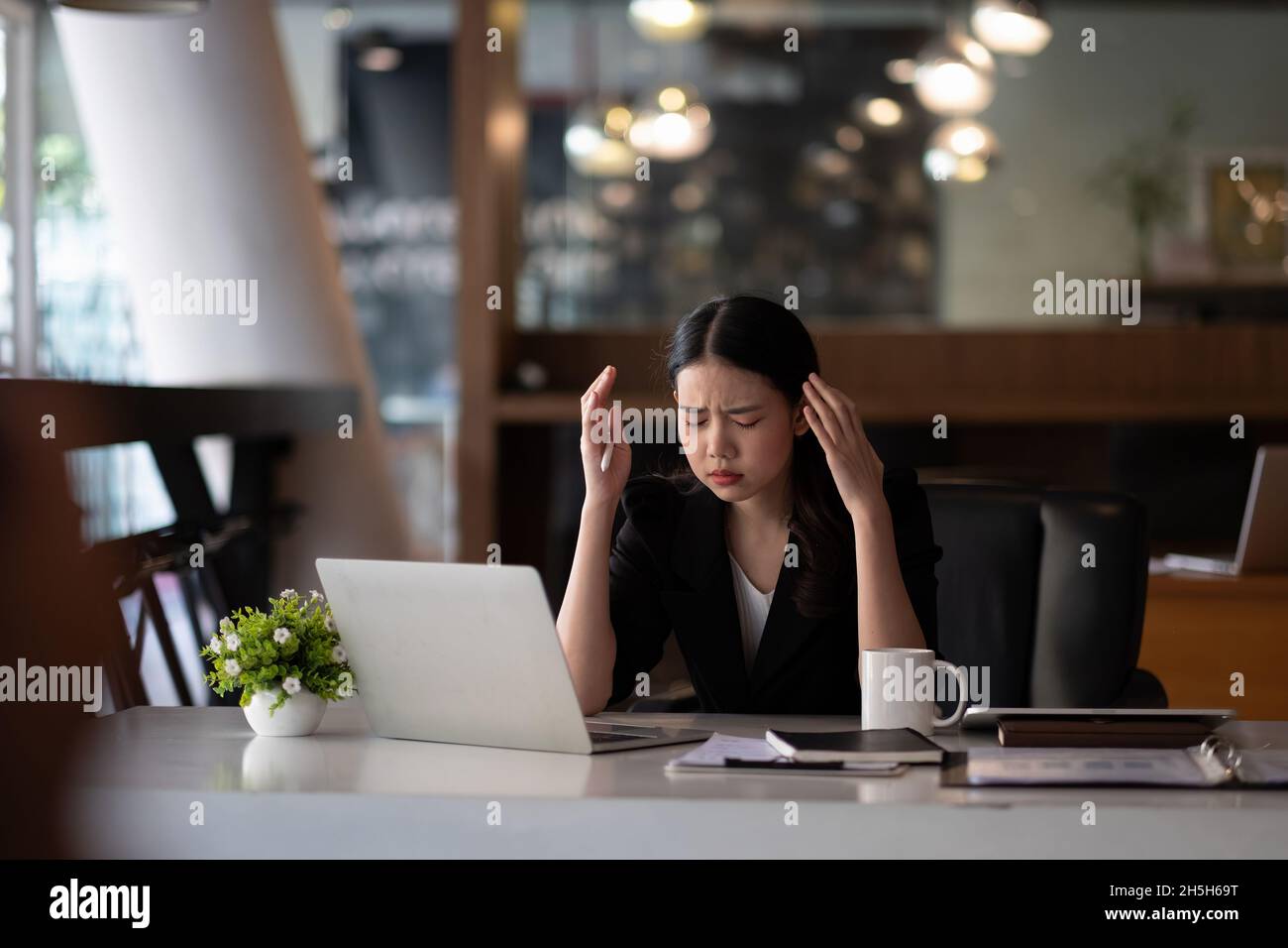 Stressed business woman working on laptop looking worried, tired and ...