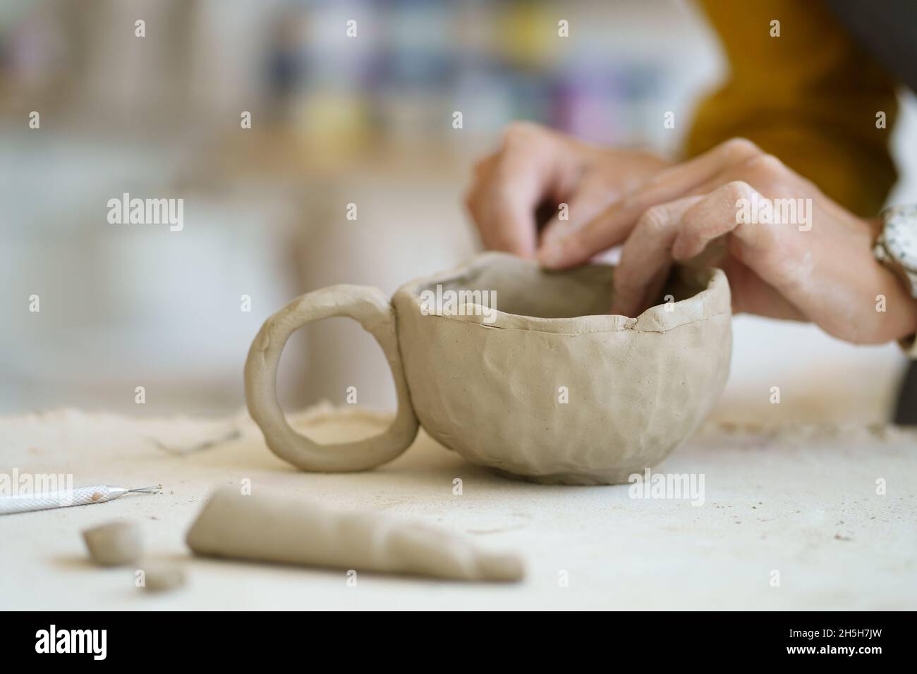 Art therapy at ceramics lesson: female hands shaping potter cup. Artist ...