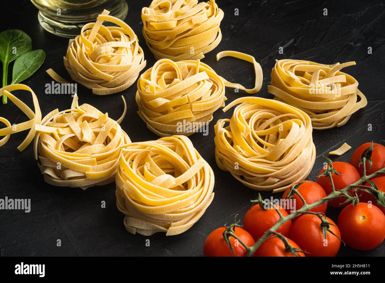 Raw tagliatelle nests Traditional Italian pasta set, on black stone ...