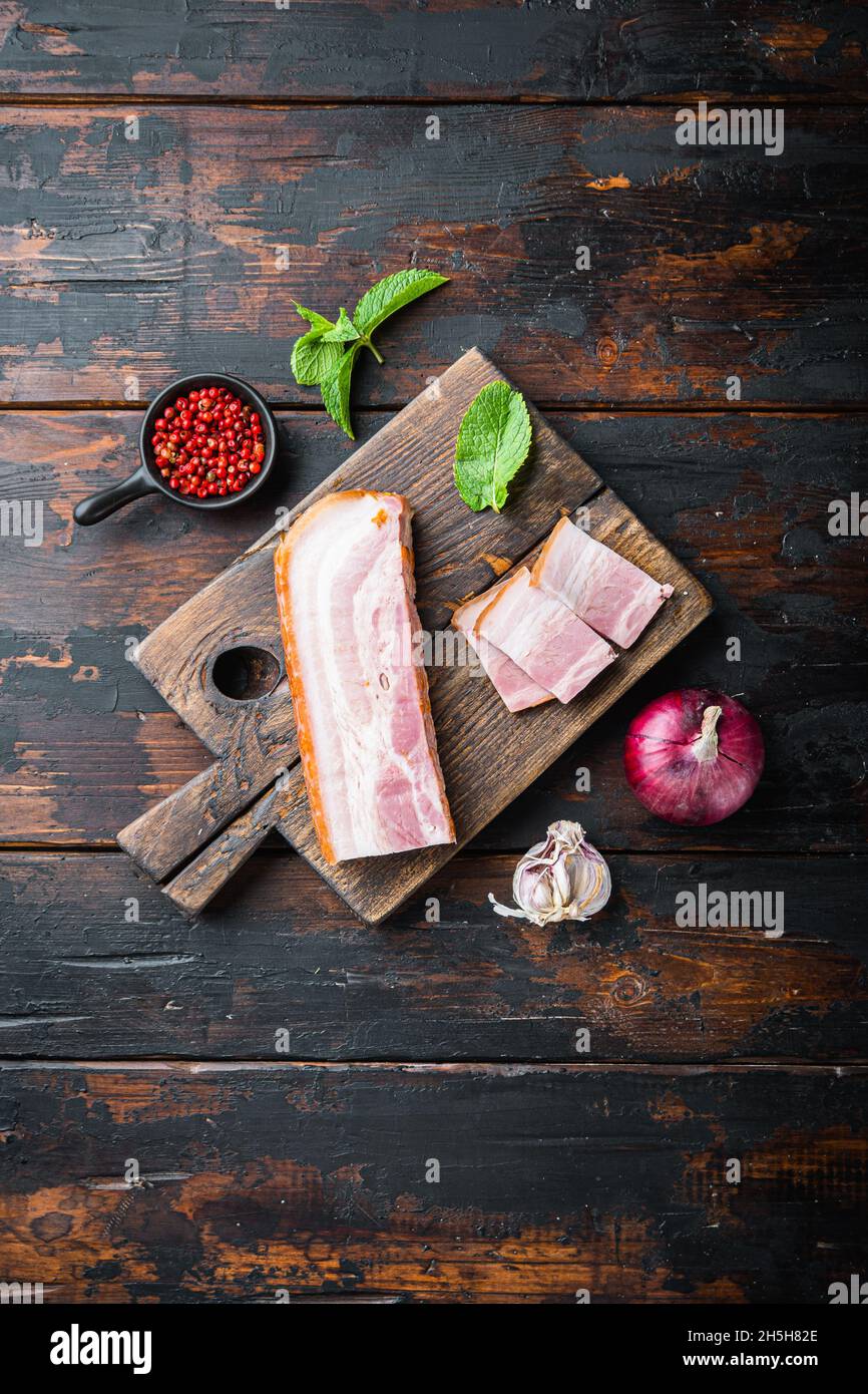 Bacon pancetta cut and sliced with herbs on wooden surface, top view ...