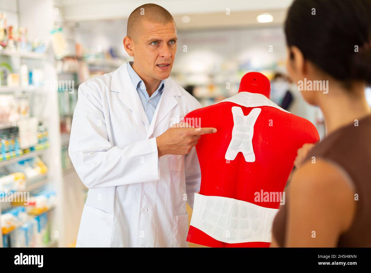 Positive pharmacist or doctor offers an orthopedic patch for the back ...