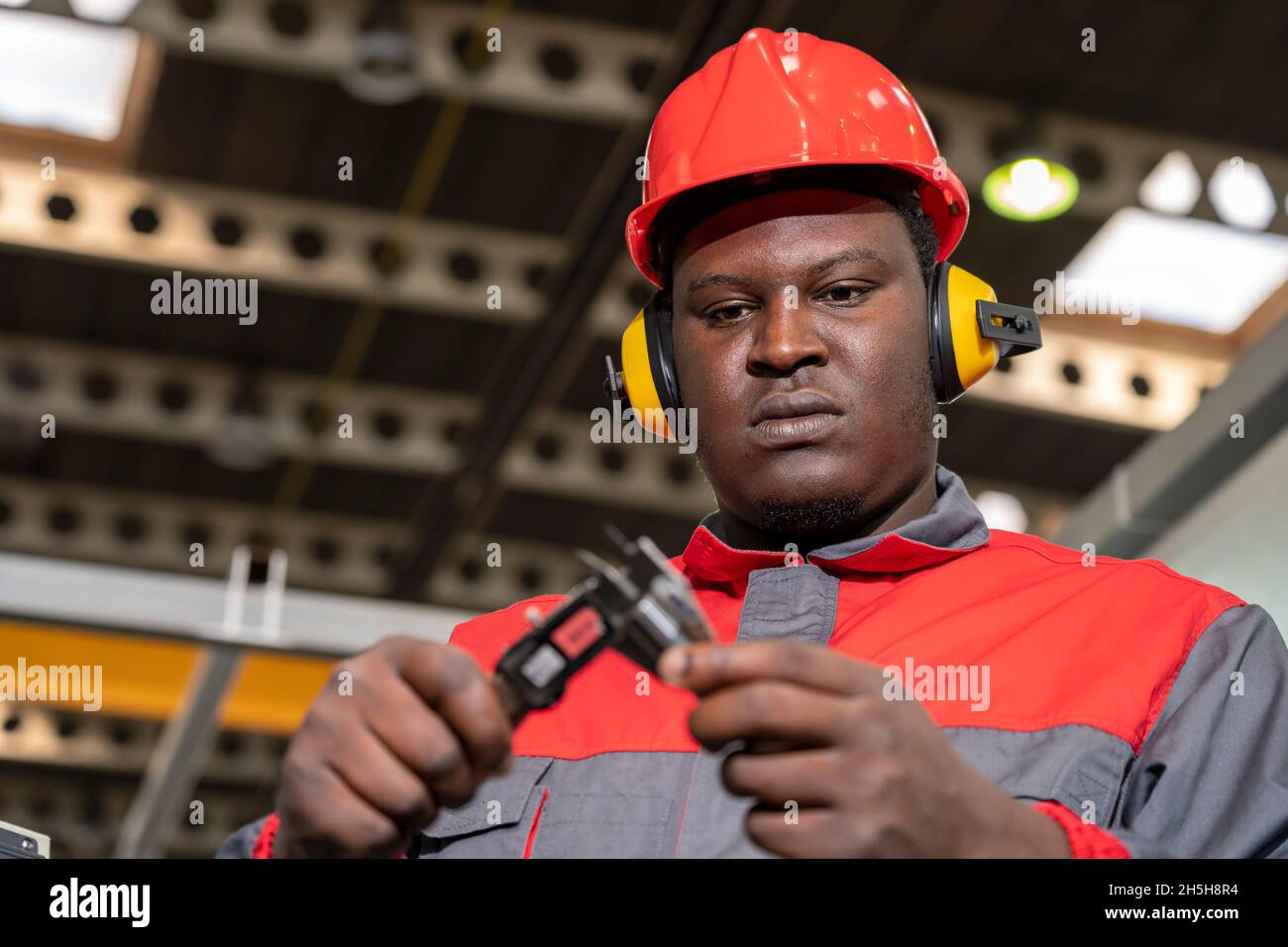 Portrait Of Black Industrial Worker In Red Helmet, Hearing Protectors ...