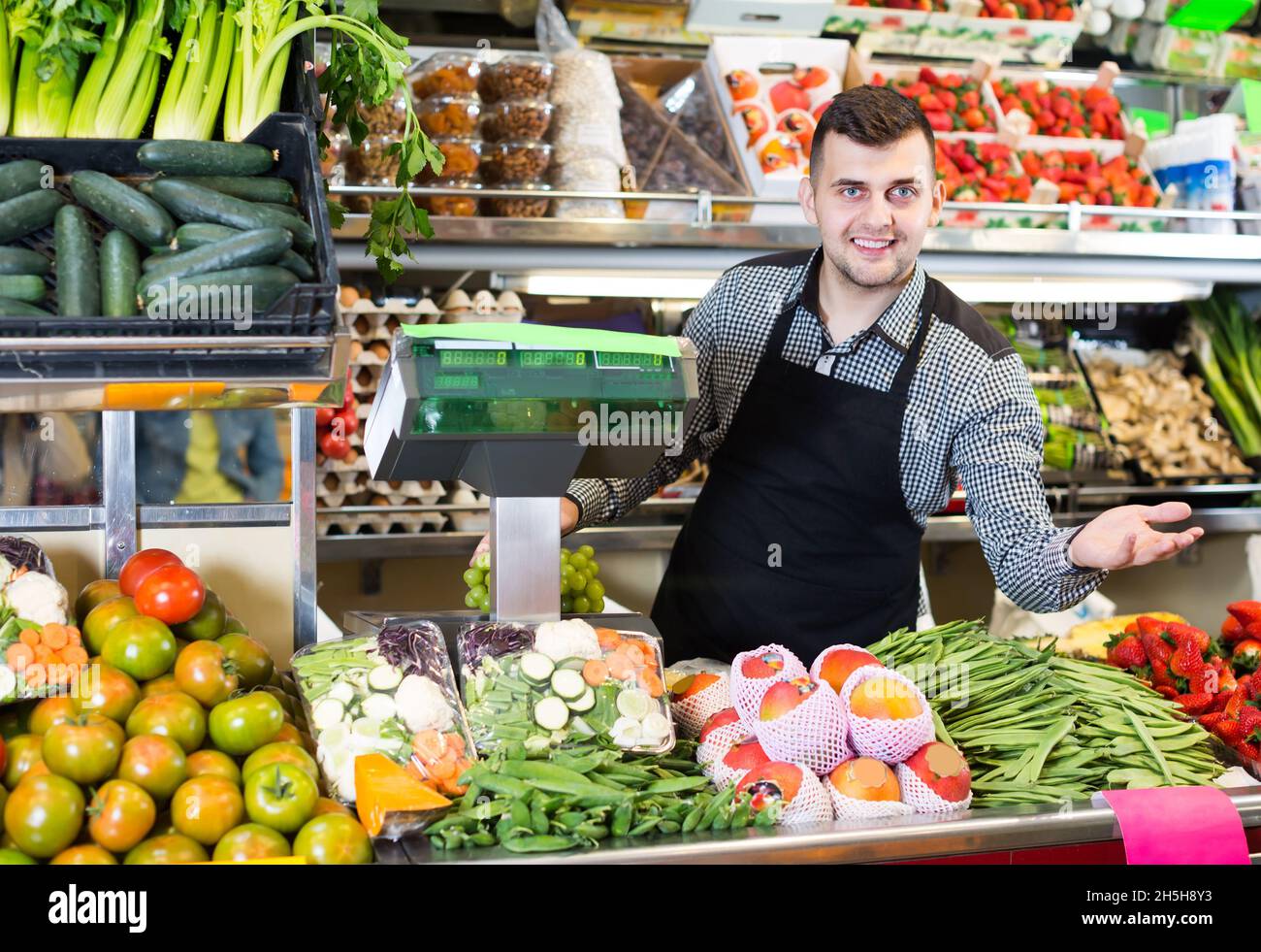 attractive male seller showing assortment of grocery shop Stock Photo ...
