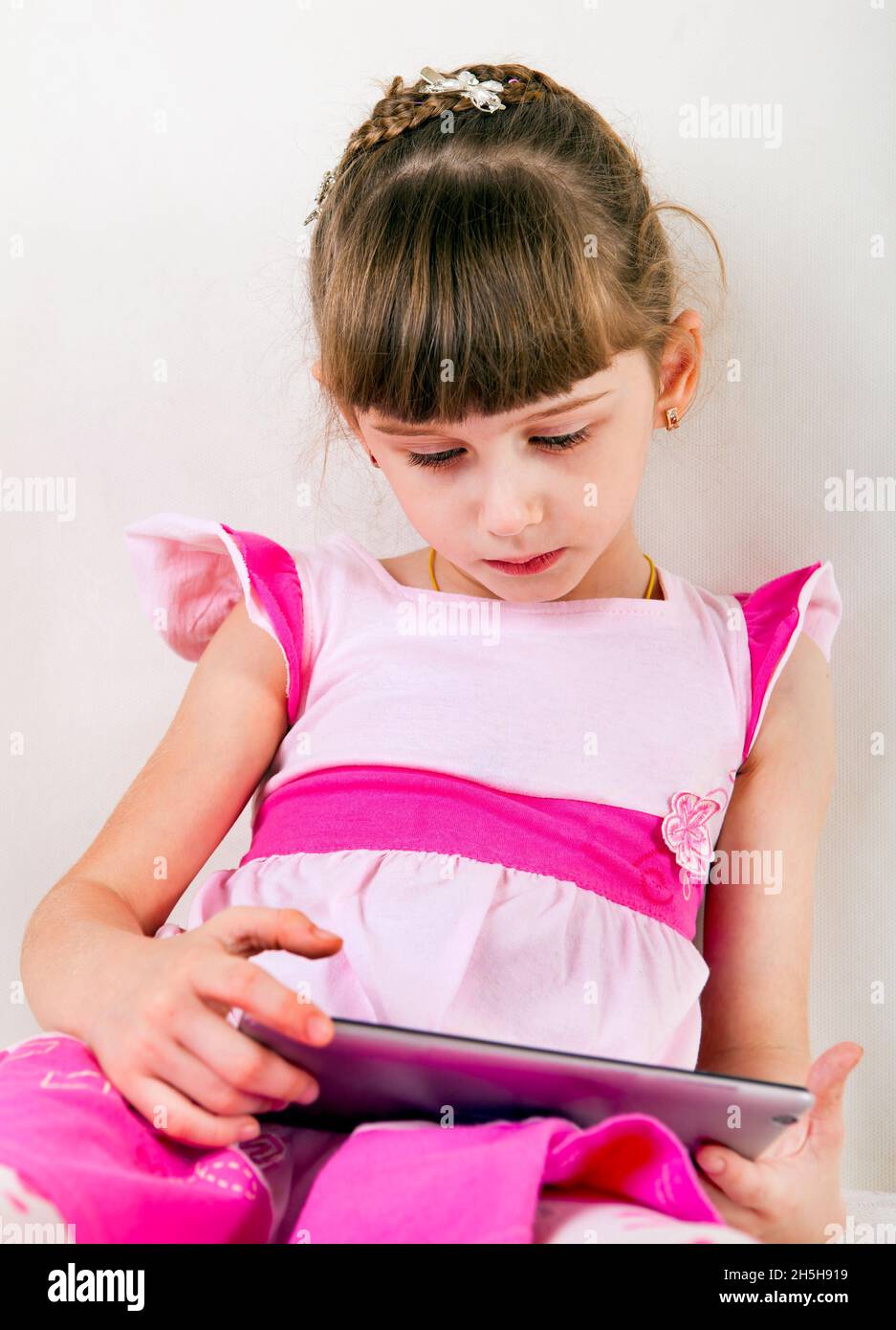 Sad Small Girl with Tablet Computer on White Wall Background Stock ...
