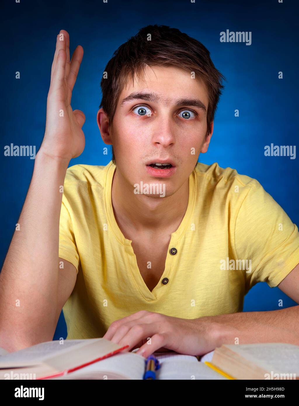 Surprised Student rise the Hand on the School Desk Stock Photo - Alamy