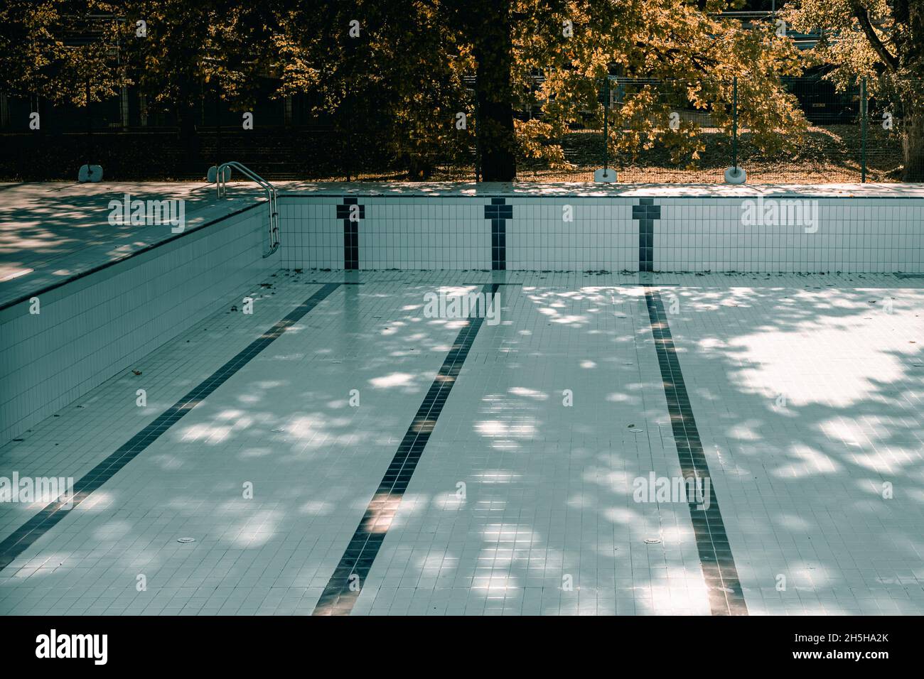 Abandoned and empty swimming pool with visible black tiles used for ...